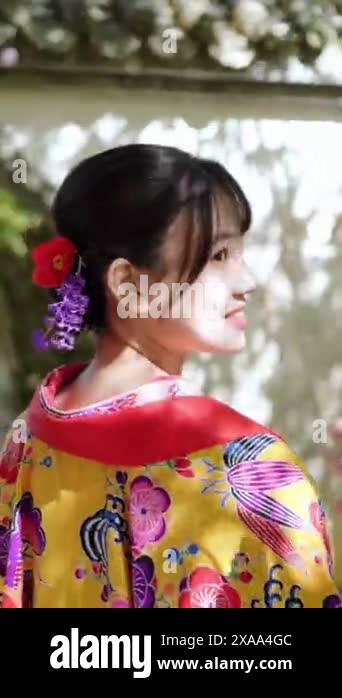A young woman in traditional Okinawan attire poses in a Chinese-style ...