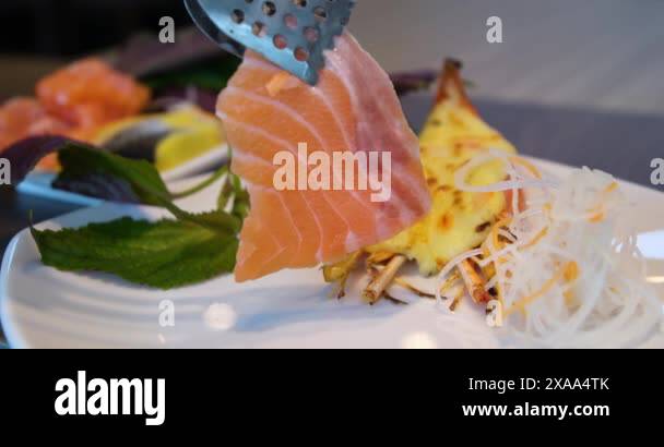 Sushi Chef Slices fresh Salmon on the sushi bar. A sushi-man slicing a ...