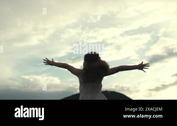 Dreaming happy kid outstretching arms up on background mountains. Preteen girl victory raising ...