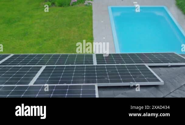 Heavy rain is falling on solar panels installed on the roof, with a ...