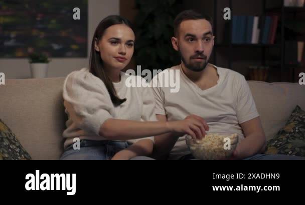Beautiful couple watching horror movie filled with jump scares tenses ...