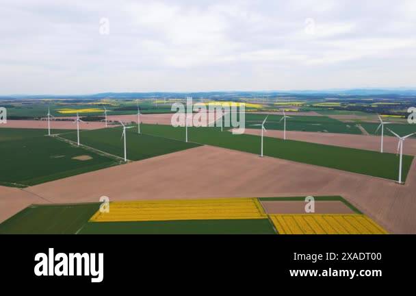 Wind generators over colorful agricultural fields with blooming ...