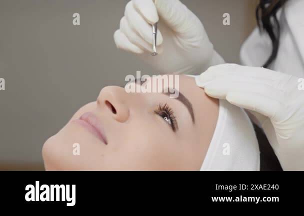 Close-up footage of a young woman receiving a professional facial ...