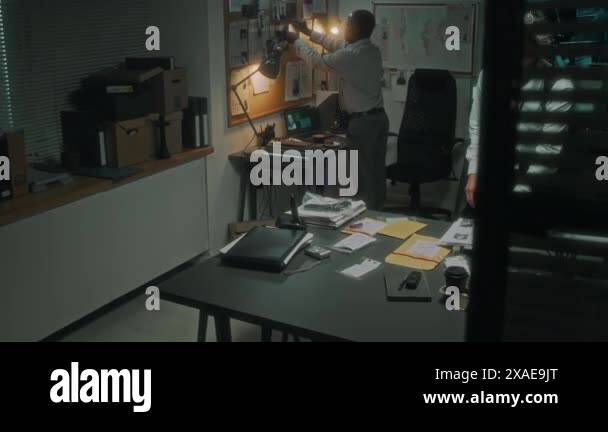 Full shot, observed from behind window blinds of busy multiethnic ...