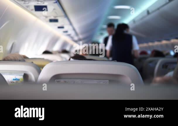 A steward and stewardess offer services to passengers seated in the ...
