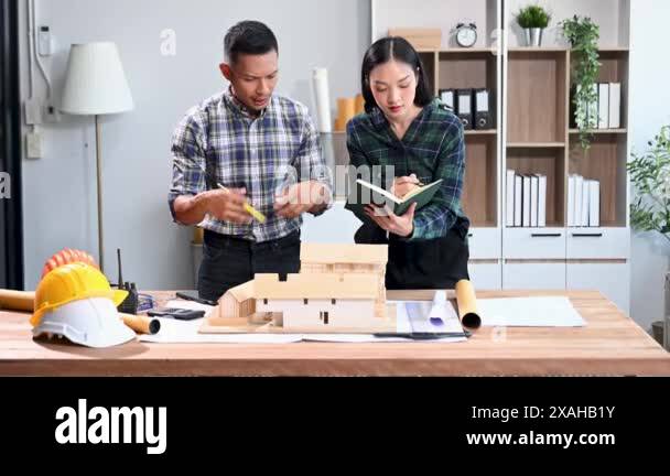 Engineer team working with on architectural project site and making model house in modern office ...