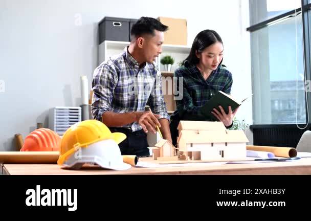 Engineer team working with on architectural project site and making model house in modern office ...