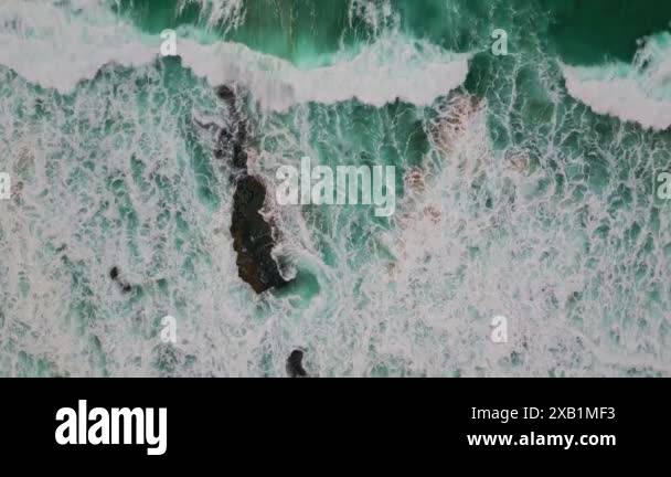 Top view turbulent waves swelling on beach with bubbling white foam ...