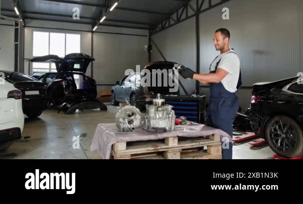 Auto Mechanic Repairing Electric Car Engine in Workshop. Auto mechanic ...