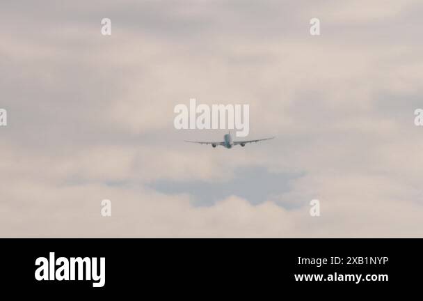 Jet airliner with unrecognizable livery rising in the sky, rear view ...
