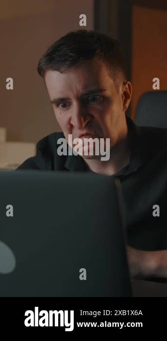 An angry hater starts to smoke Looking at the laptop screen. Anger and ...