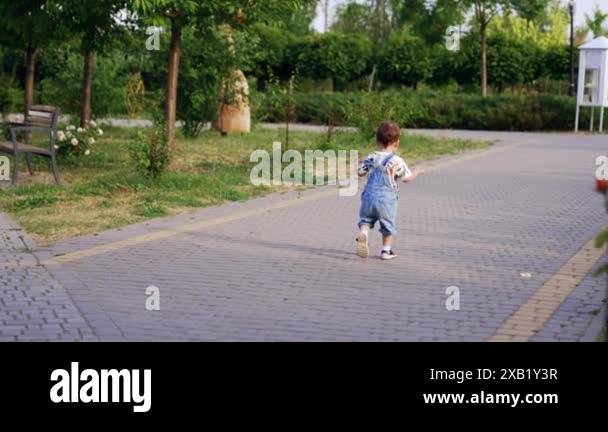One year old toddler running in the beautiful summer park. Little kid ...