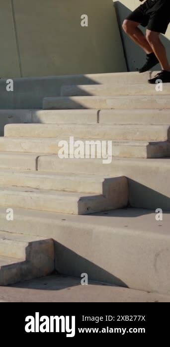 Vertical unrecognizable legs of mature man athlete running down stairs ...