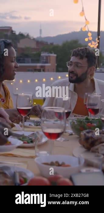 Vertical video of a Group of people eating during an outdoor dinner ...
