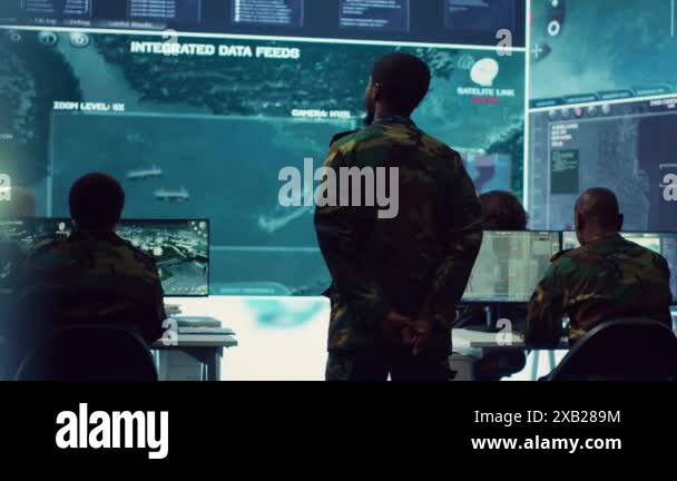 Staff sergeant monitoring satellite live imagery on a big screen ...