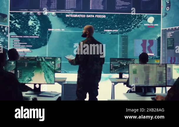 Army officer examining real time satellite data on big screen in ...