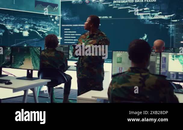 Female military officer supervising radar surveillance footage to input ...