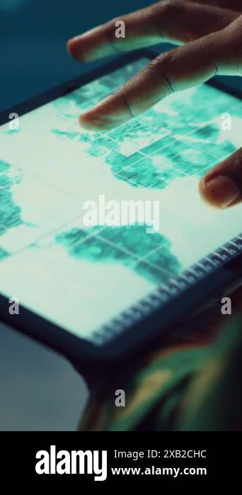 Vertical Video Army soldier reviews targets on a satellite world map to ...