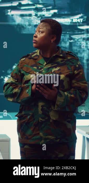 Vertical Video Female military officer supervising radar surveillance footage to input and ...
