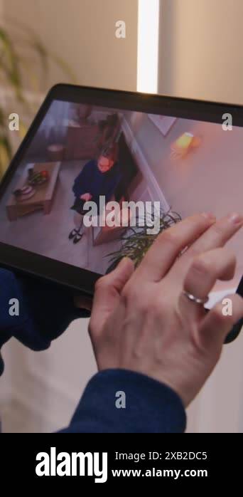 Caucasian woman checks security camera after installation. Woman sets ...