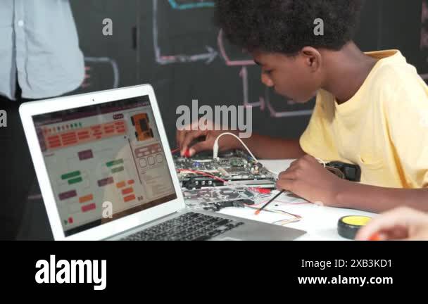 Cute african boy learning to use electronic tool while laptop display ...