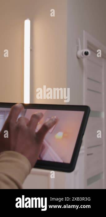 African American man checks security camera after installation. He sets ...