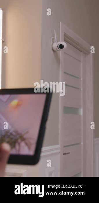 Woman checks security camera after installation. She sets up CCTV ...