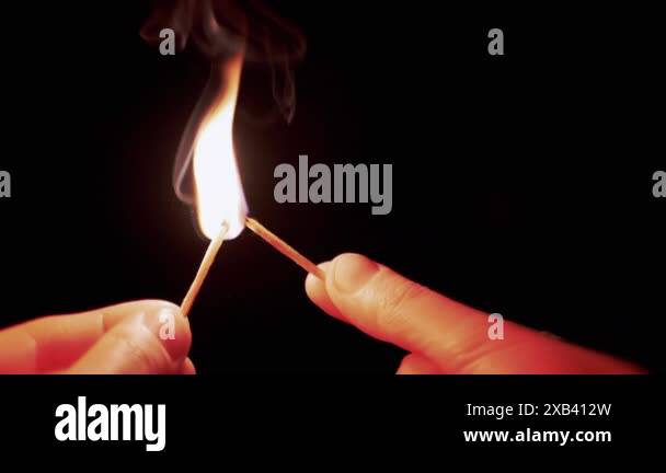 Two Burning Matches in Hands in Red Lighting on a Black Background ...