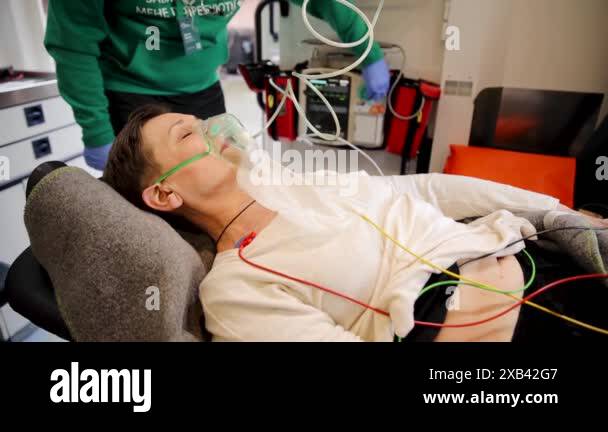 Female patient breathing through oxygen mask. Support in ambulance next ...