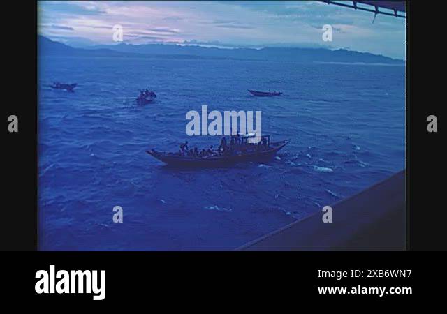 VIETNAM - 1975 - US Navy sailors help pull boats of Vietnamese refugees ...