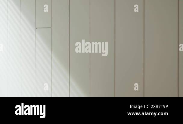A close-up of a minimalist white panel wall with soft, natural shadow ...