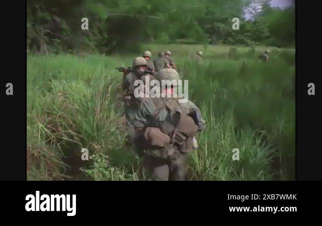 1965 - Soldiers walk through rice paddies, a soldier fires a M72 LAW ...