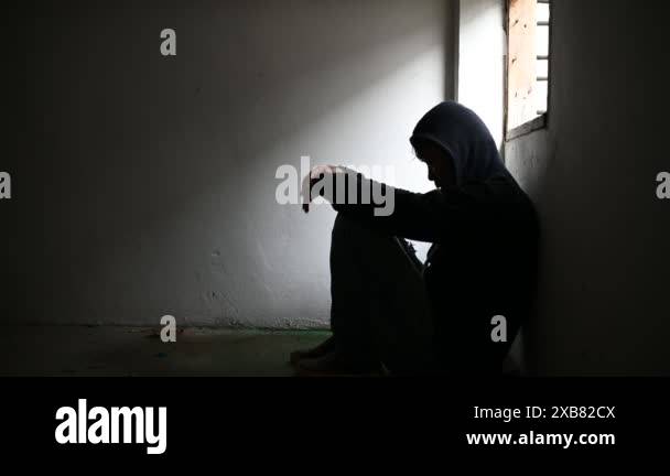 Asian man drug addict sitting in the corner of room in deserted place ...