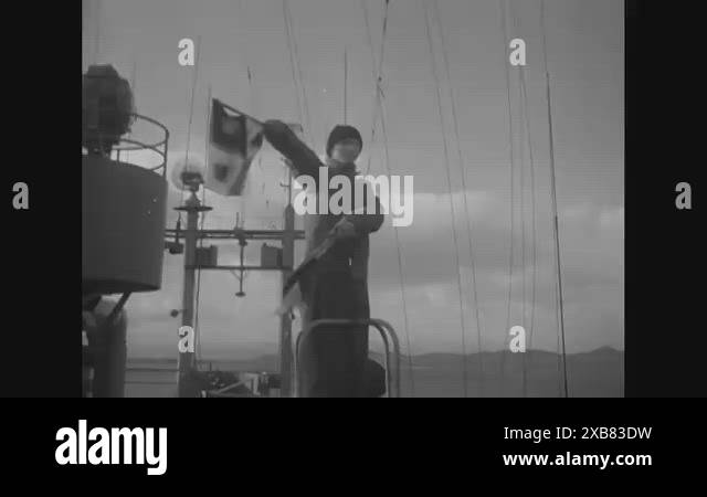 1950 - Man on ship signals with flags during the Korean War in Hungnam ...