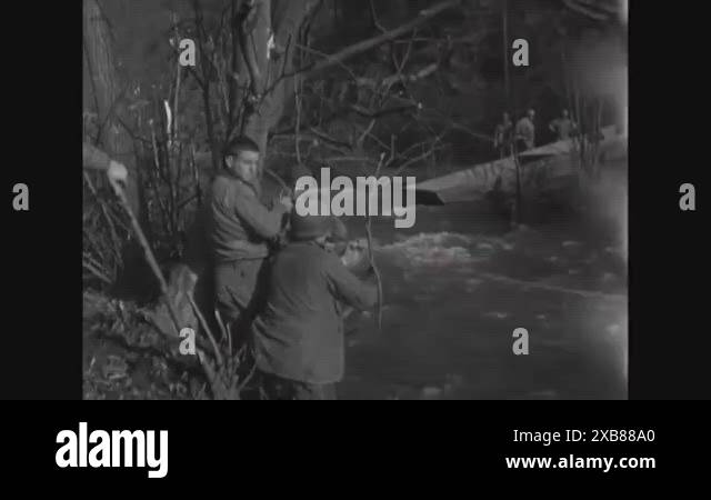 1945 - Stakes are driven into the ground and pontoons put in place by ...