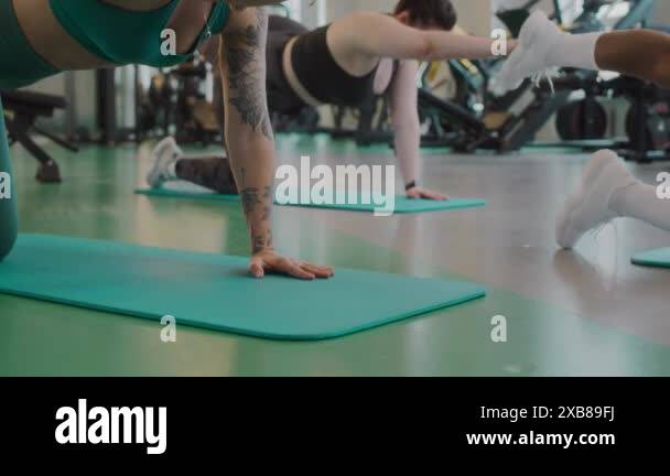 Positive young Caucasian tattooed female fitness coach showing ...