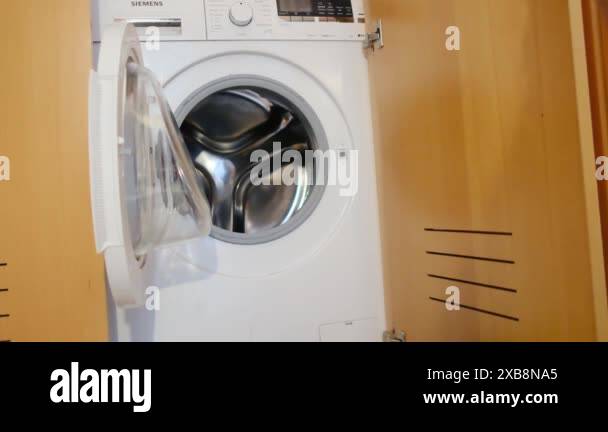 Man washing children's clothes in washing machine. Break with the ...