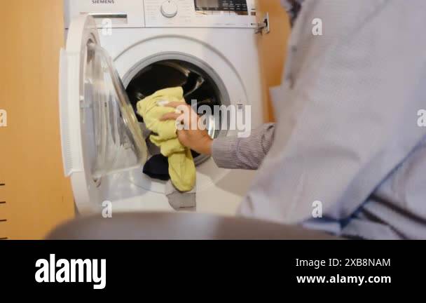 Man washing children's clothes in washing machine. Break with the ...