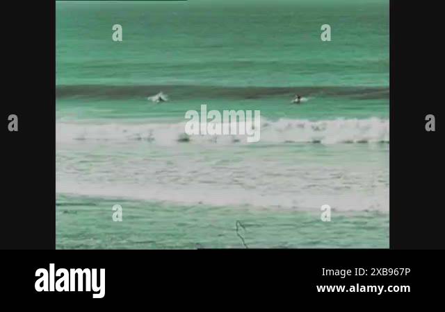 Two nearly identical scenes feature two surfers catching a wave at ...