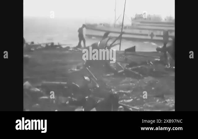 1945 - Men survey extensive damage on USS Bunker Hill while a hospital ...