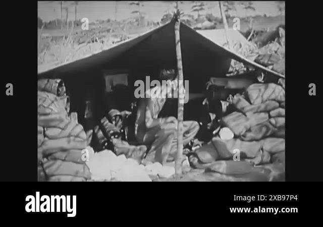 1945 - Man measures gun powder as men load and fire howitzer in Okinawa ...