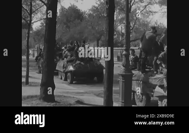 1944 - Army trucks drive through streets in Paris. French woman and ...