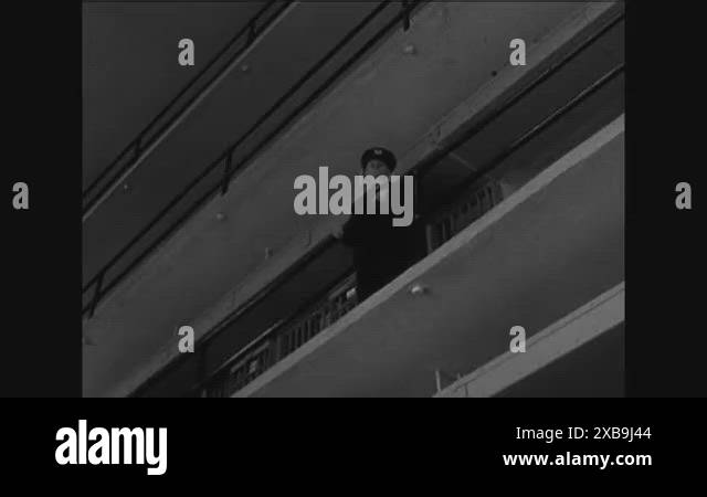 Cell doors close in a prison with a guards watching, including a guard ...