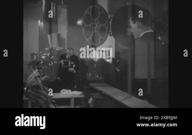 A projector with motion picture film, an actor, an actress, a studio ...