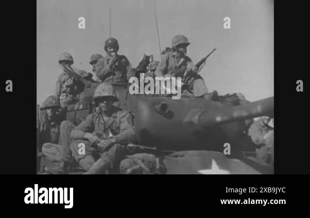 1951 - Marines pass a burning Russian tank and enter a flaming village ...