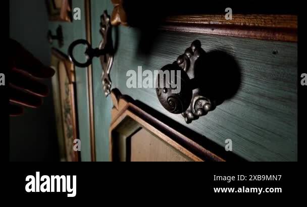 Mysterious and tense mood.Enigmatic Wooden Door with Key.hand opens a ...