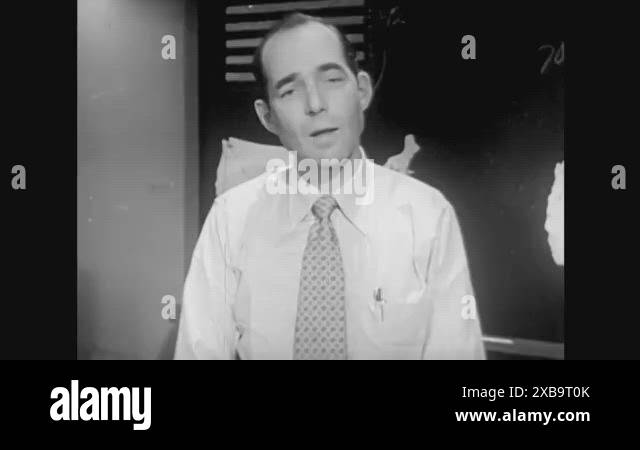 A presenter in front of a chalkboard with maps of the United States on ...