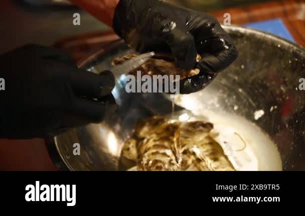 The process of opening an oyster shell using a knife. Restaurant worker ...