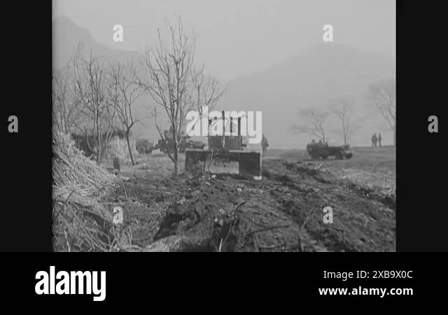 1951 - US Army engineers use a bulldozer to push dirt, trees and rubble ...
