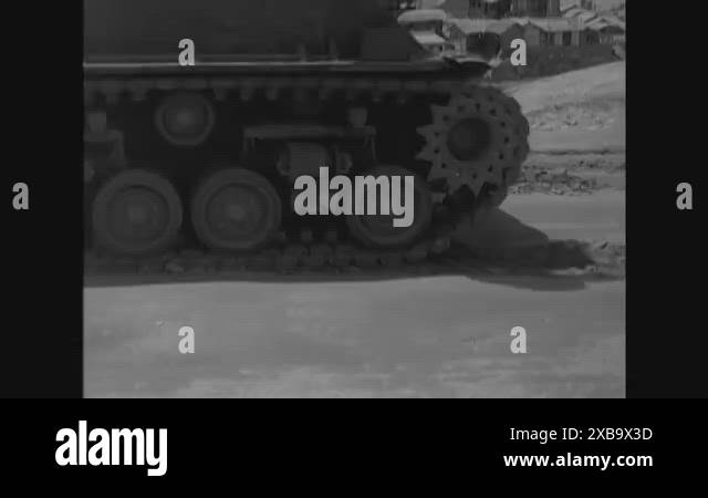 1951 - A Sherman tank is driven past American soldiers in an ...